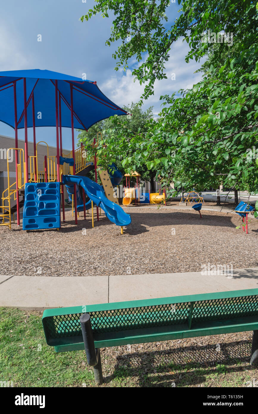 Bench and playground with colorful structure equipment near Dallas ...