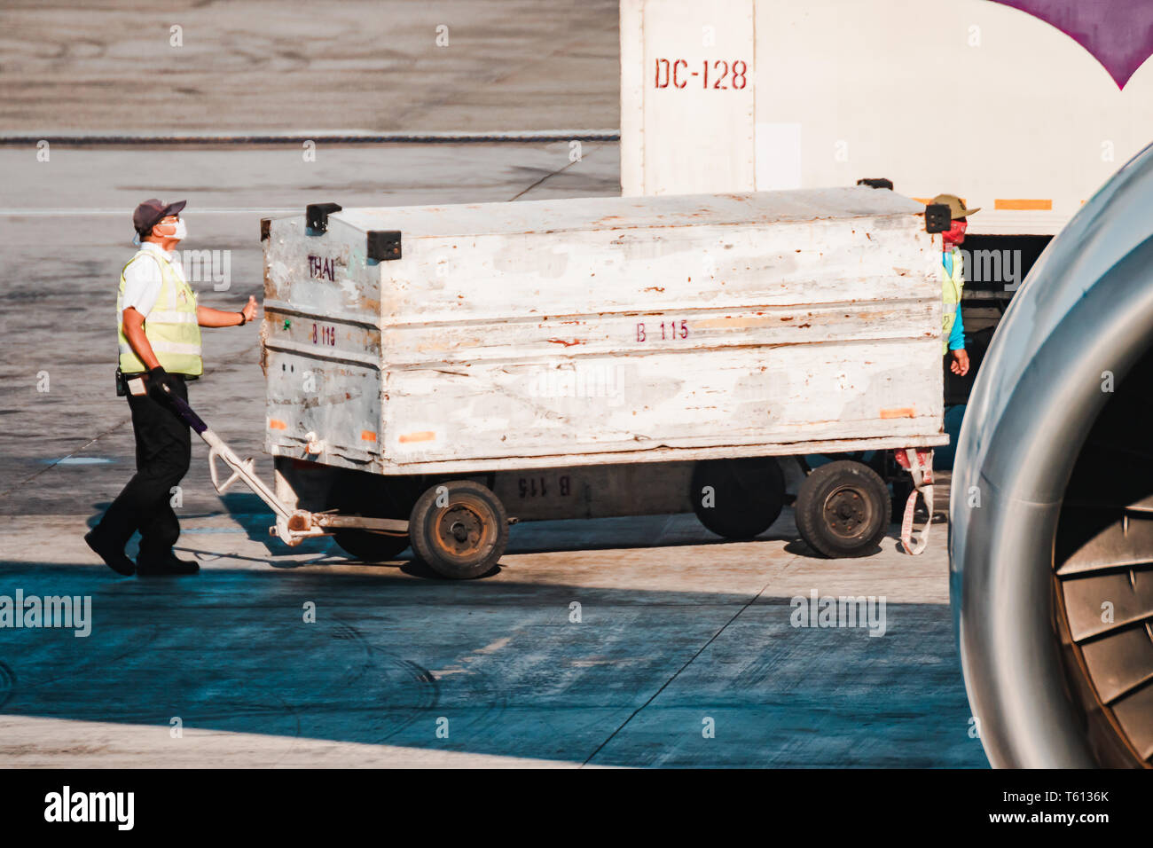 Asian ground staff (ground crew) transporting cargo and luggage to the ...