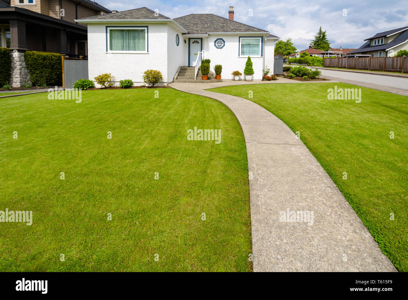 Main entrance of residential house with concrete walkway over the front ...