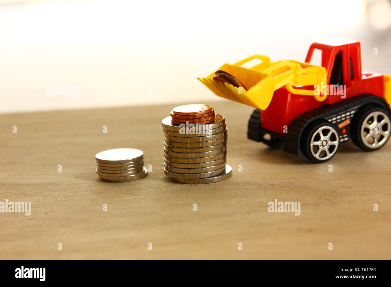 coins stack with construction toy on wood floor,business concept Stock ...