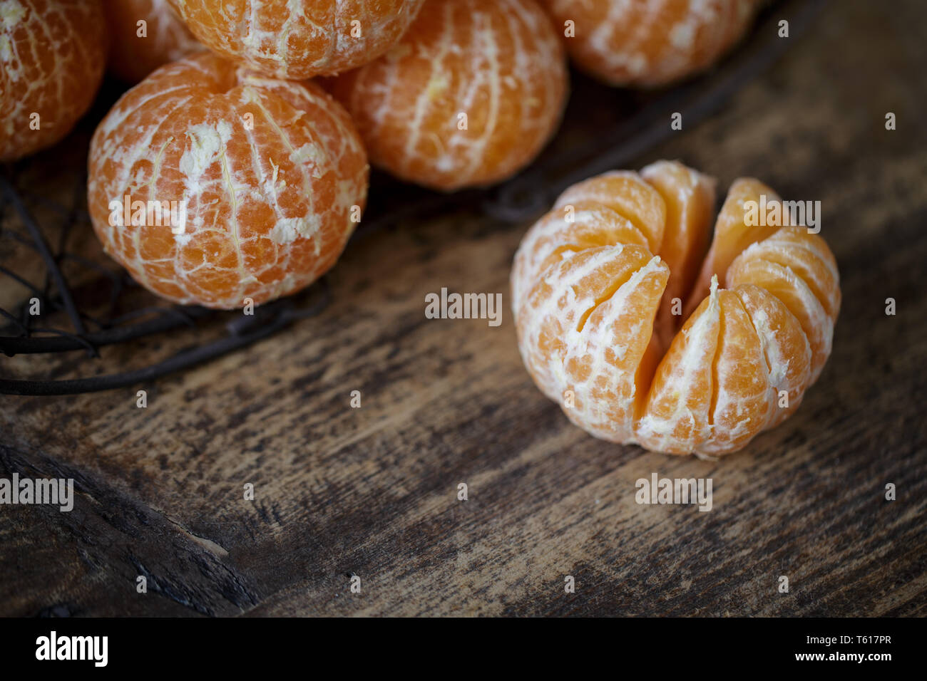 Fresh peeled Clementines in Old Metal Basket Stock Photo - Alamy