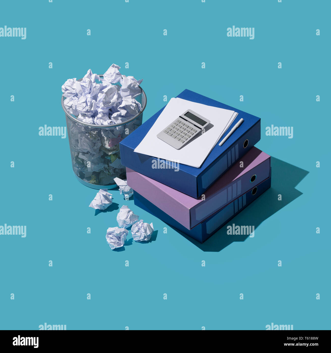 Trashing old paperwork and office management: full trash bin, pile of ...