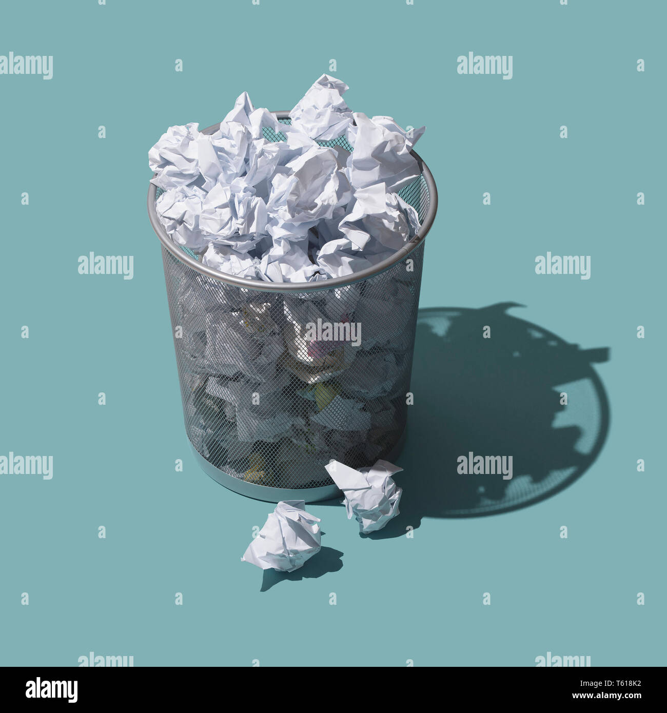 Trash can filled with crumpled paper, frustration and rejection concept ...