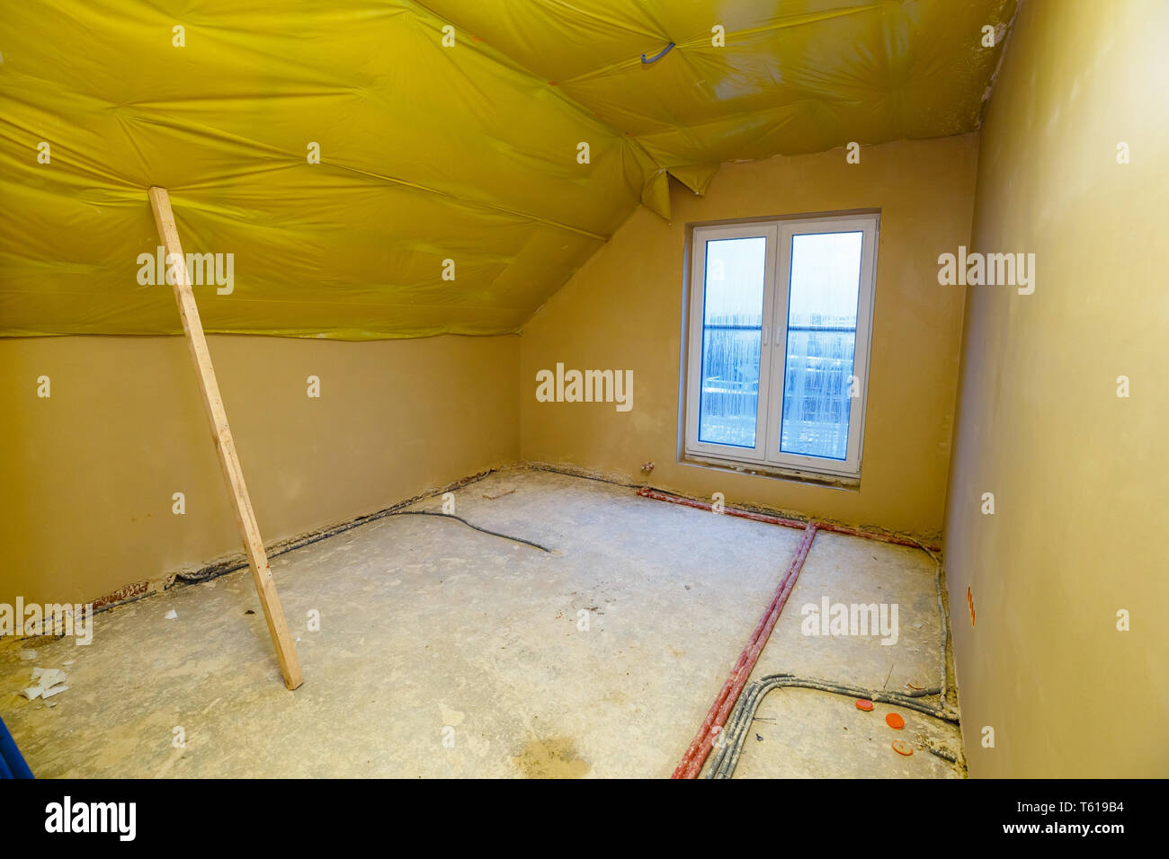 Empty room in a house under construction with fresh screed and plaster ...