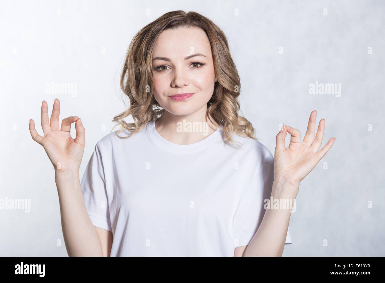 Handsome young woman shows ok sign. Body language concept Stock Photo - Alamy