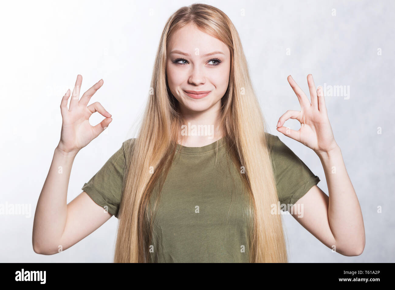Young beautiful smiling woman shows ok sign. Body language concept Stock Photo - Alamy