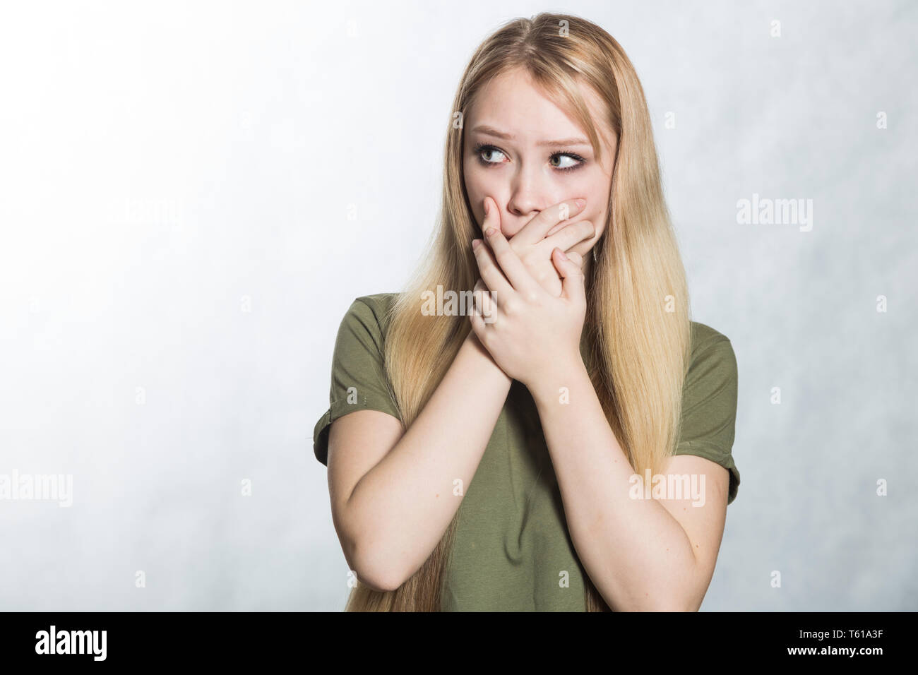 Surprised young woman covers mouth in shock Stock Photo - Alamy