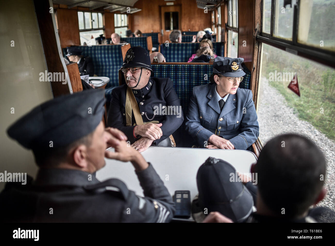 People dressed in WWII period uniforms ride on a steam train during the ...