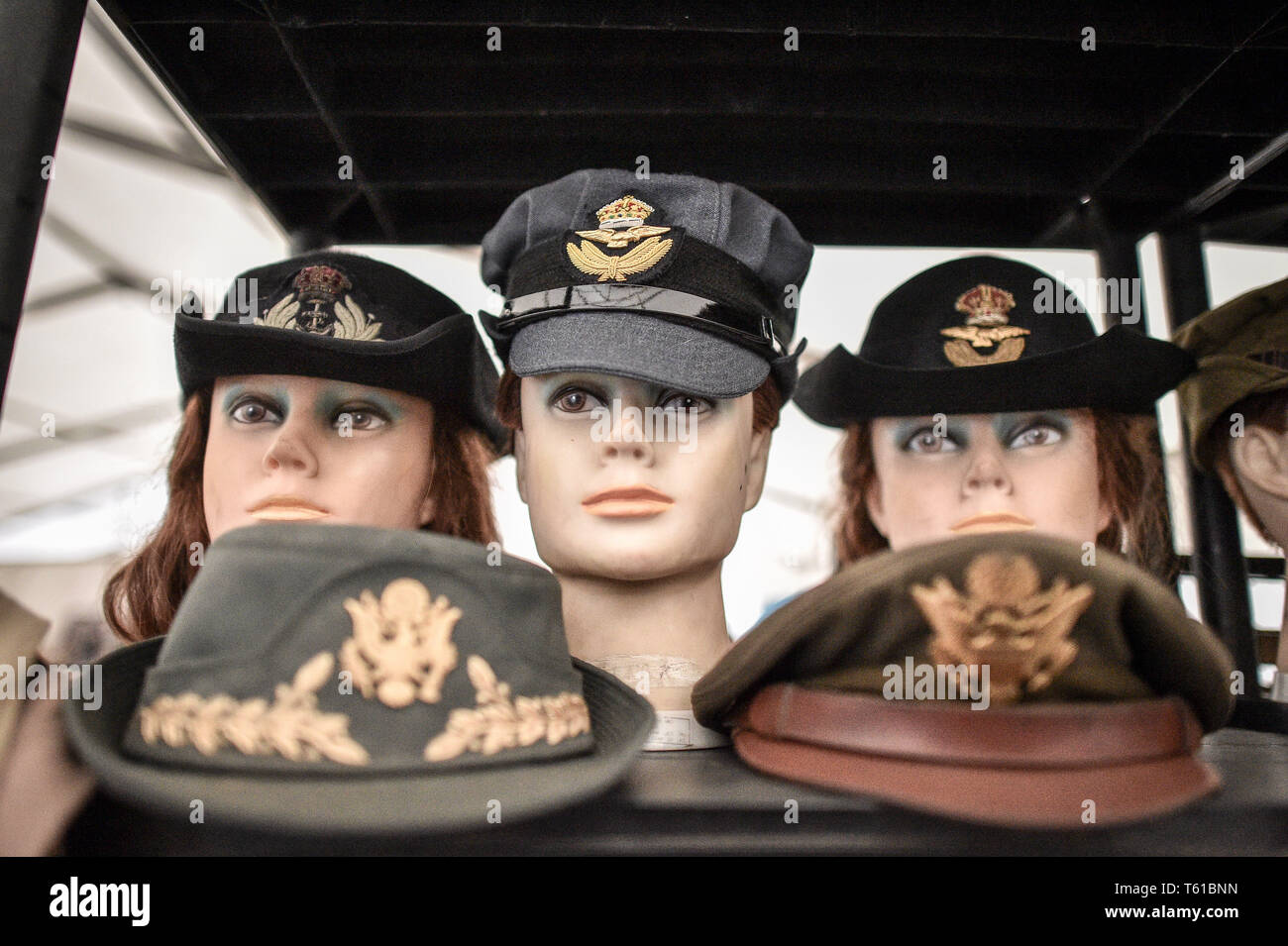 Period WWII military hats on a clothing stall during the Wartime in the ...