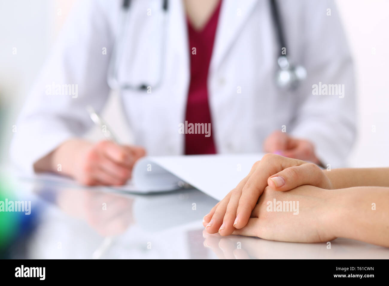 Unknown doctor woman consulting patient while filling up an application ...