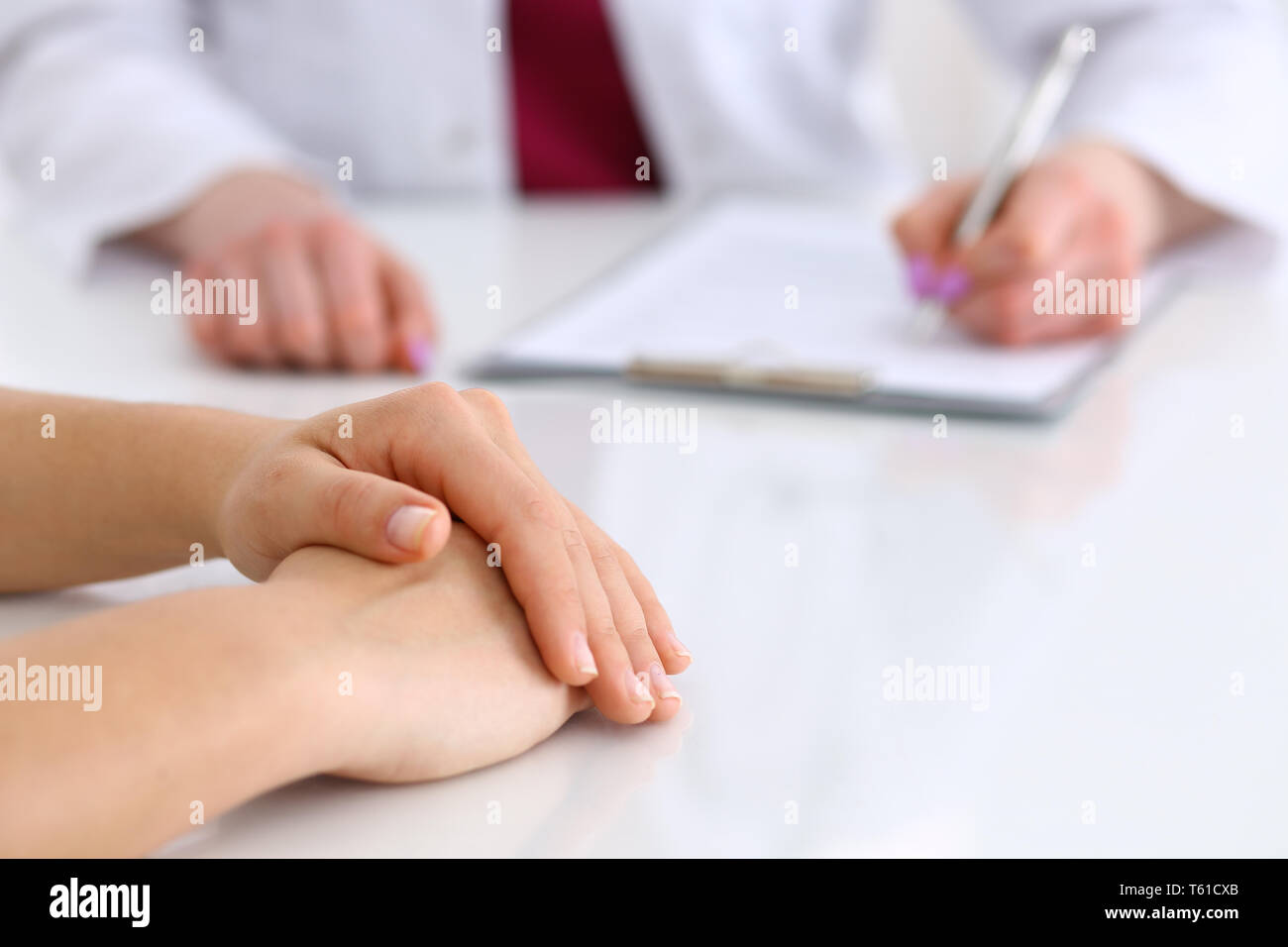 Unknown doctor woman consulting patient while filling up an application ...
