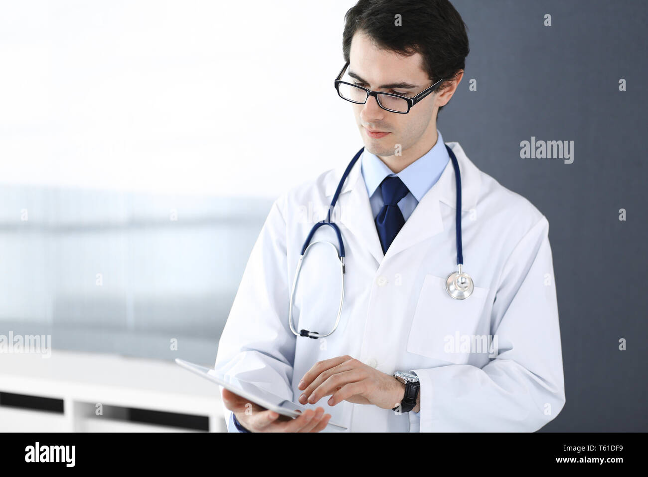 Doctor man using tablet computer for network research or virtual ...