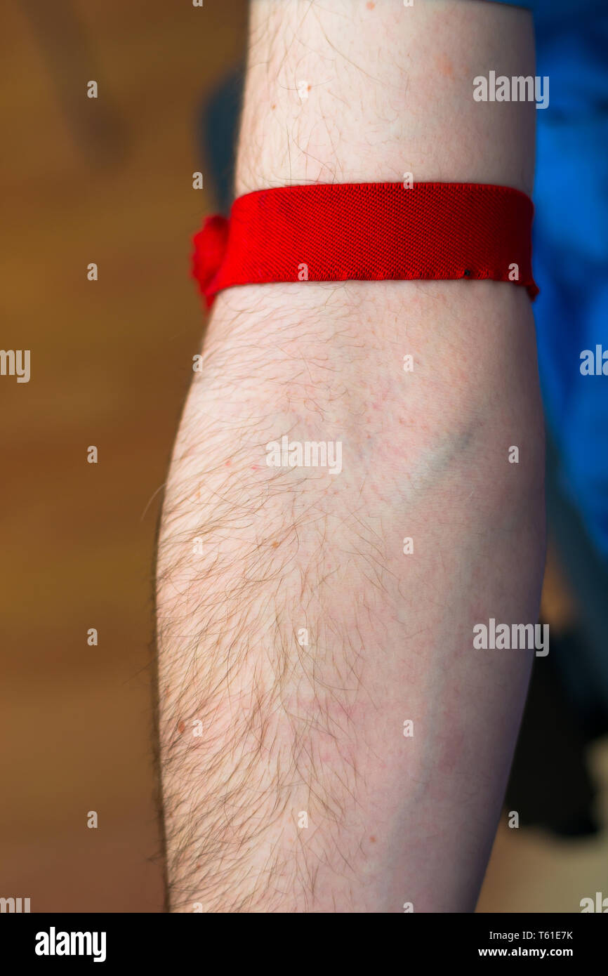 the red tourniquet on a man's hand Stock Photo - Alamy