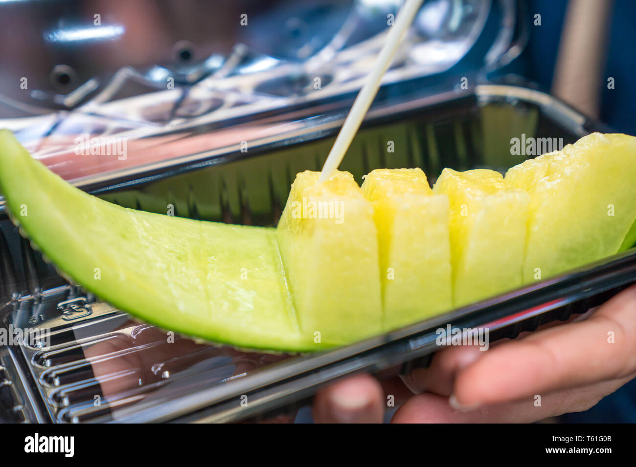 Japanese cantaloupe in plastic bos on women hand, in fish market with ...