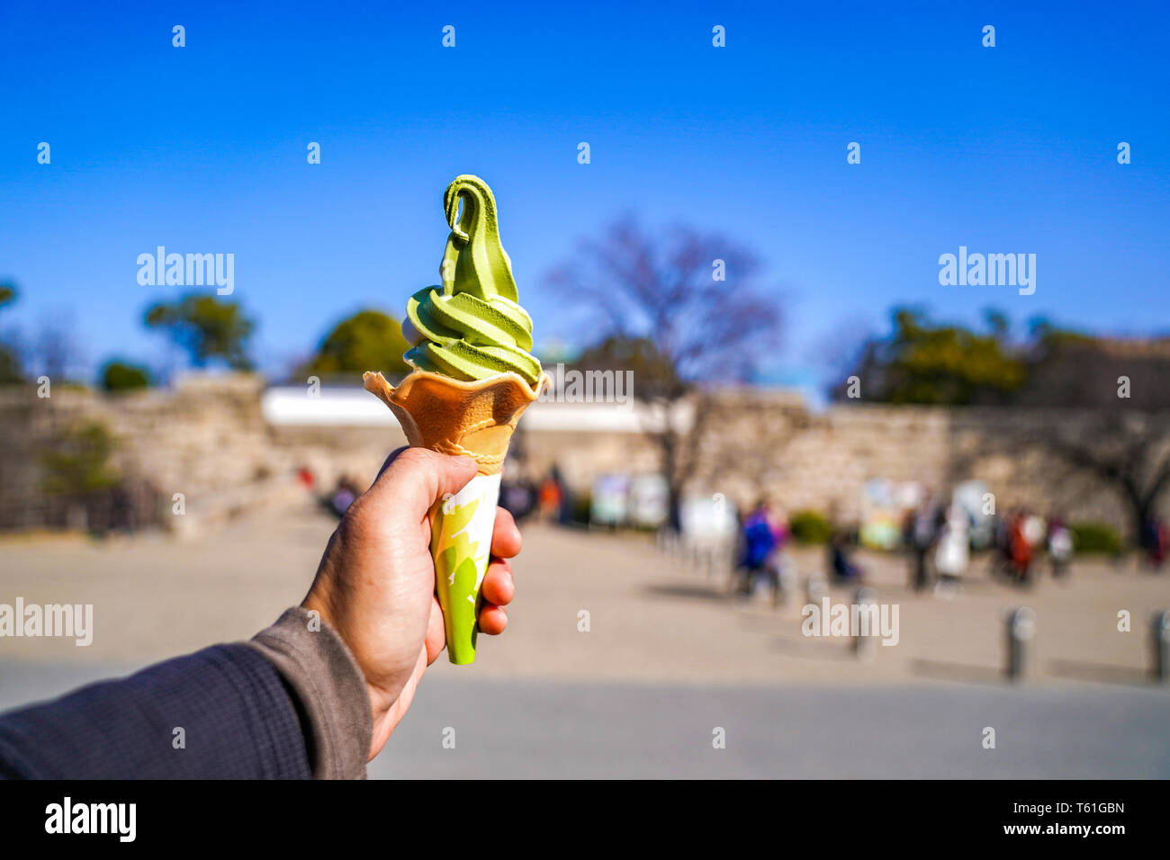 green tea icream cone in man hand with blur background, Japan Stock ...