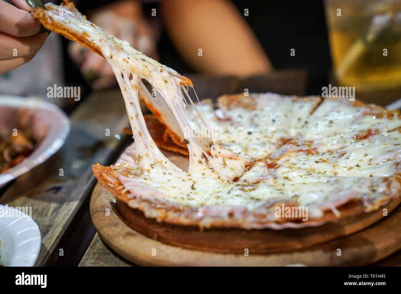 Woman's hand take pizza pices out from pizza plate in foodtruck event ...
