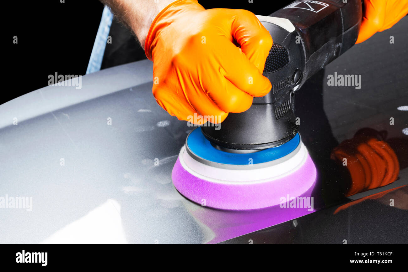 Car polish wax worker hands applying protective tape before polishing ...