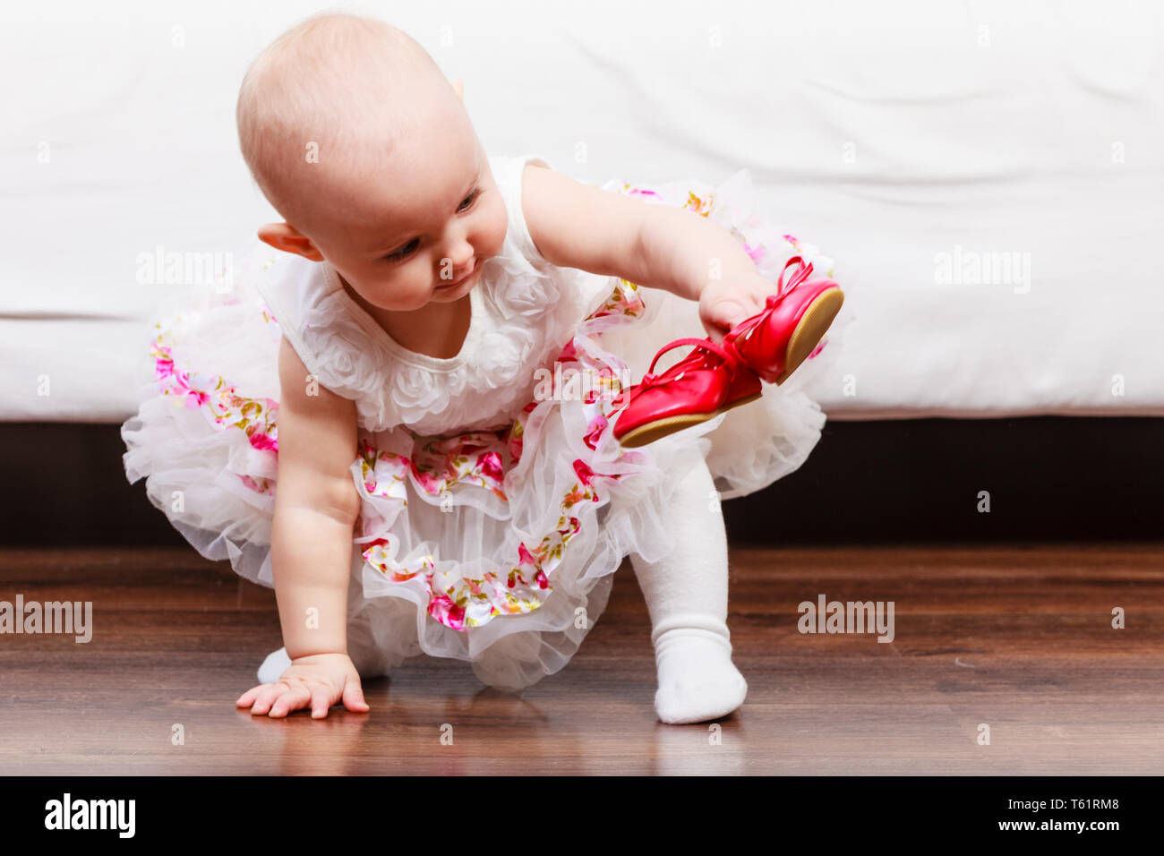 Lesson of walking. Sweet adorable baby girl making steps at home ...