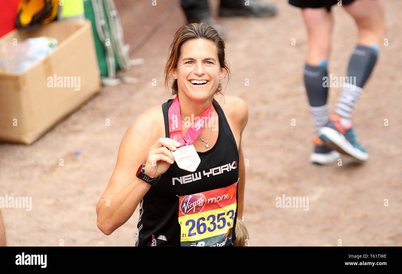 A runner poses with her medal after crossing the line during the 2019 ...