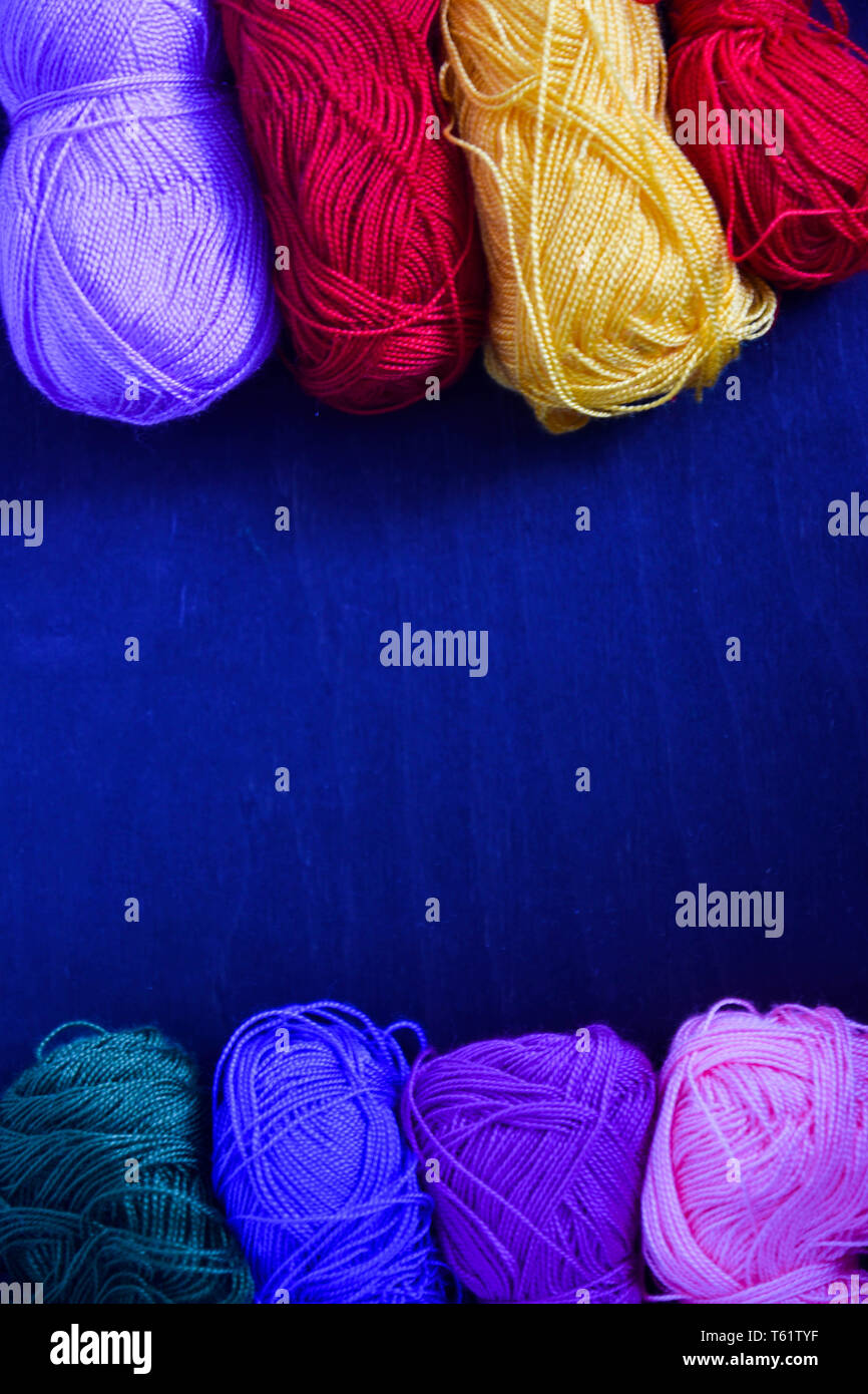 knitting threads on a blue background Stock Photo - Alamy