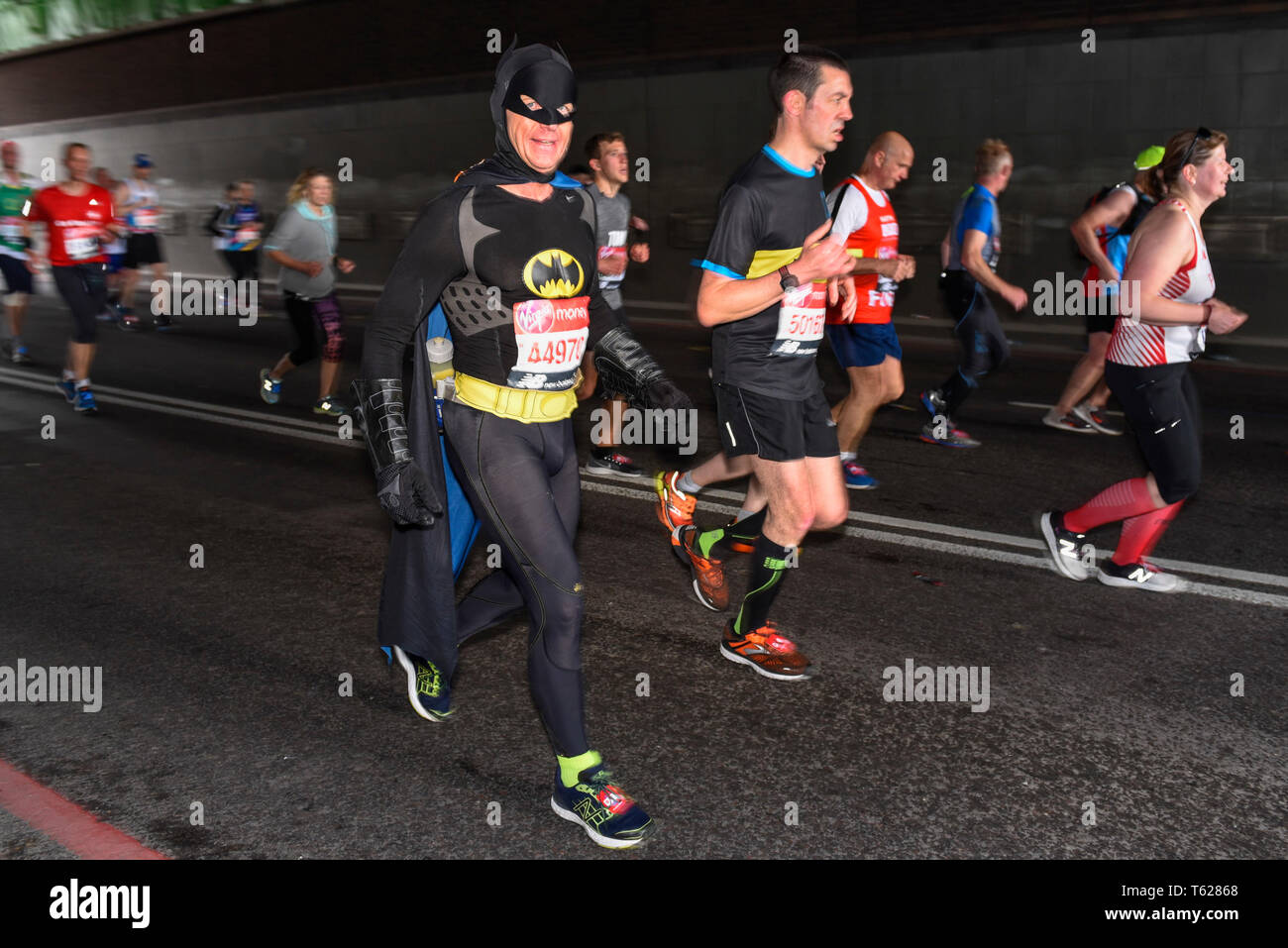 London, UK. 28 April 2019. A runner in a Batman costume joins other ...