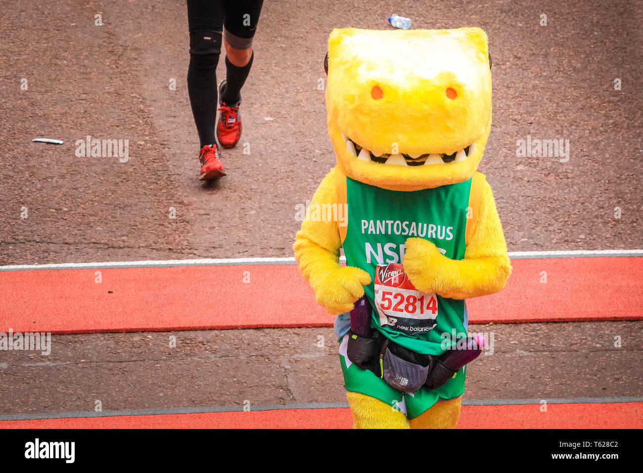 London, UK. 28th Apil 2019. The NSPCC 'Pantosaurus' crosses the finish ...