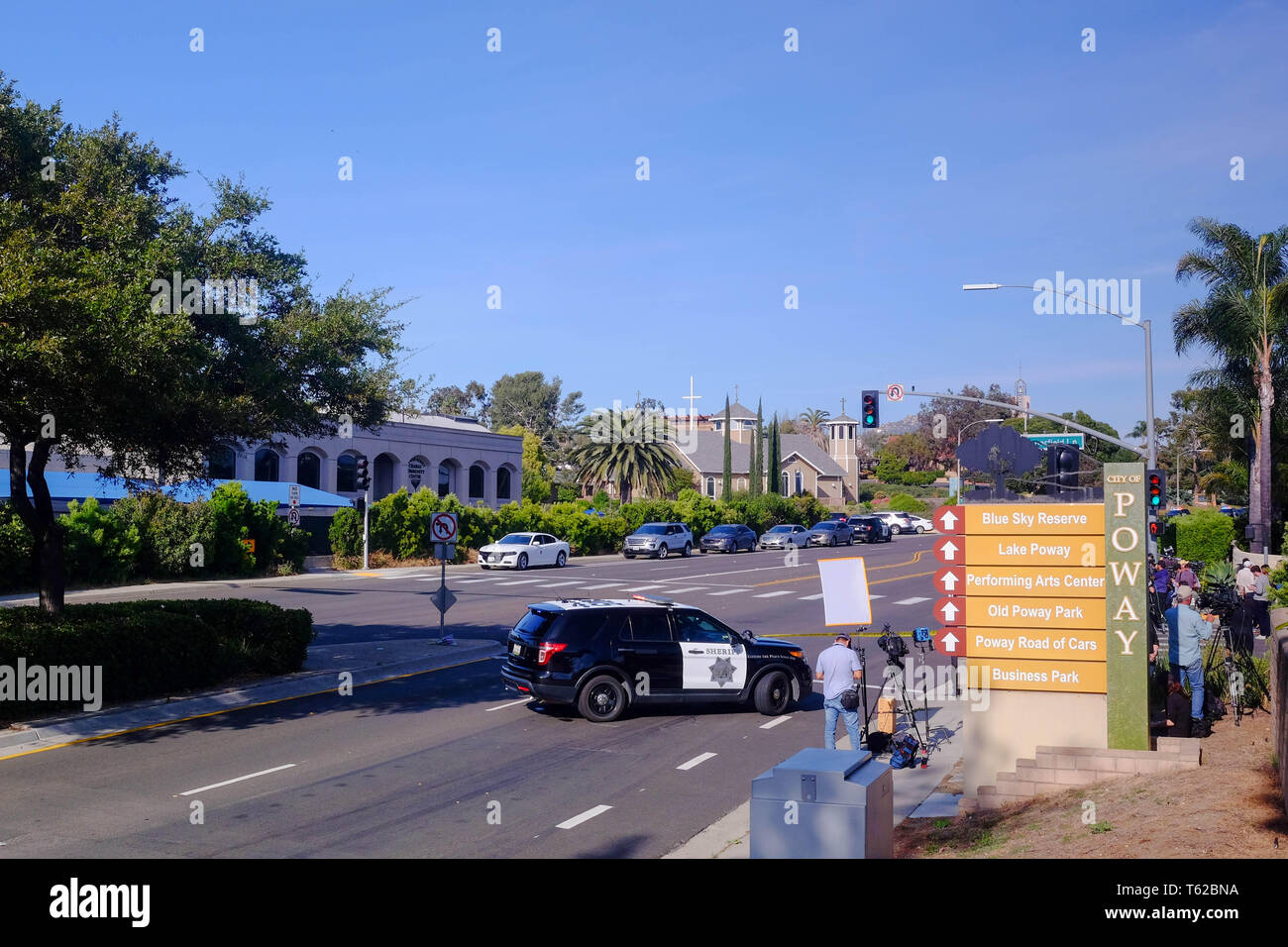 Police and reporters stand by the Poway synagogue where a gunman shot ...