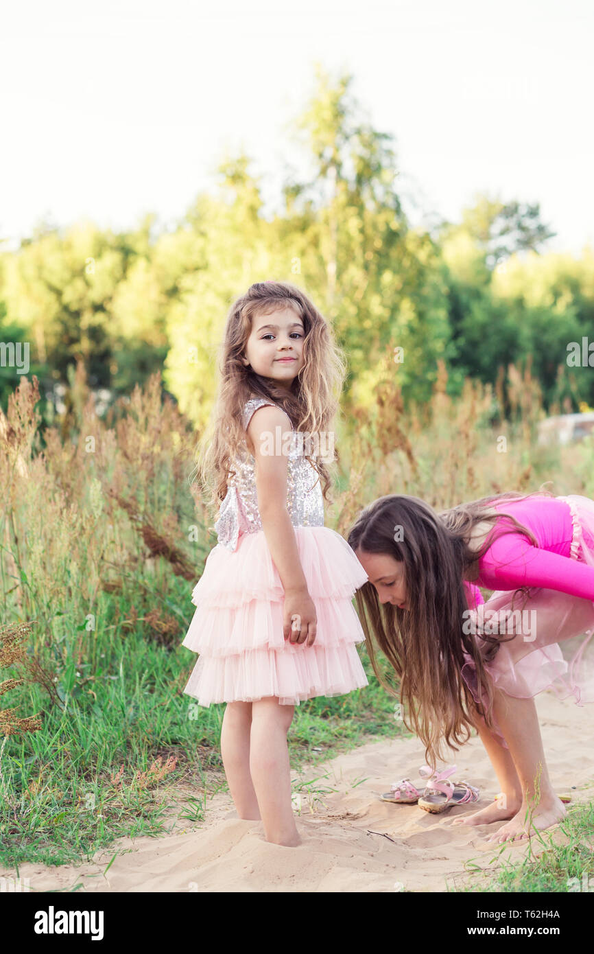 Portrait of Two Happy little girls having fun and playing with sand at ...