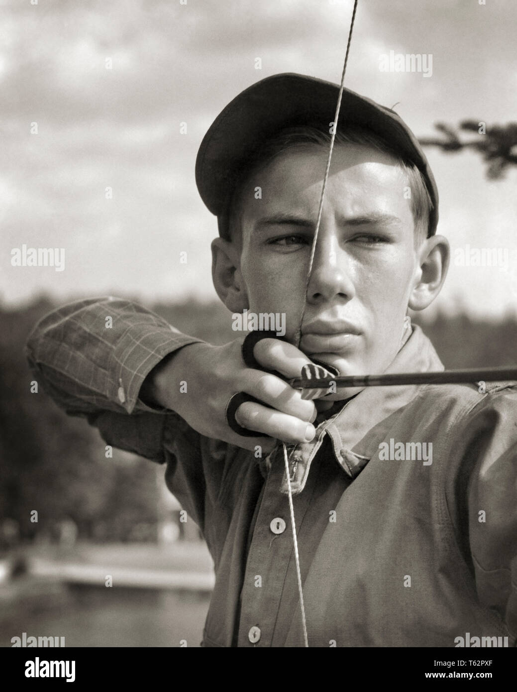 1930s SERIOUS YOUNG MAN BOY AT SUMMER CAMP DRAWING AND AIMING BOW AND ...