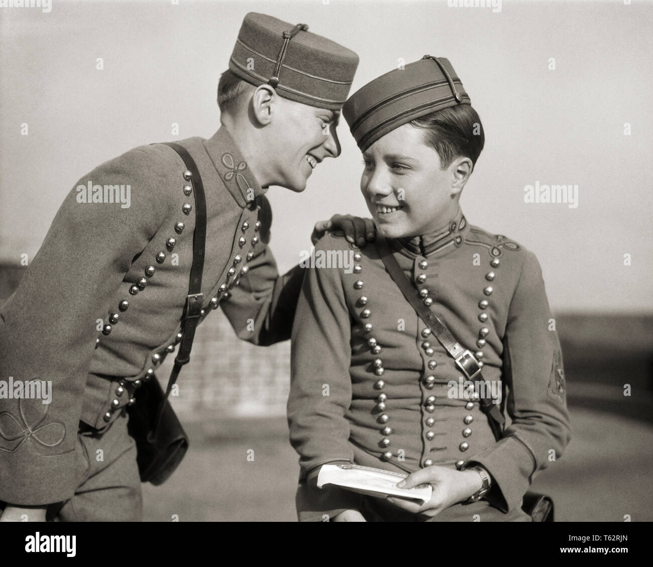 1920s 1930s TWO SMILING HOTEL BELLHOPS IN UNIFORM SHARING A SECRET ...