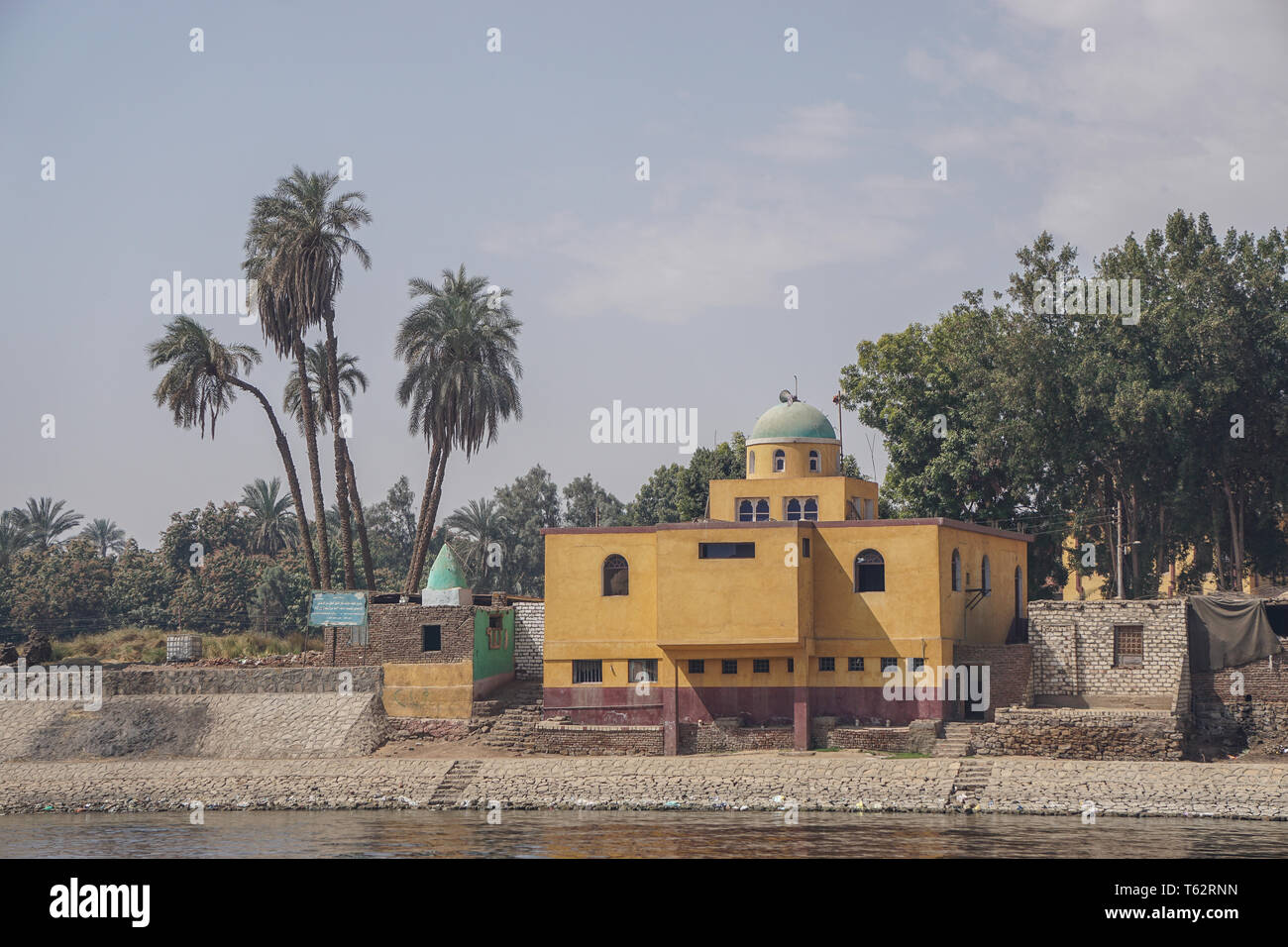 Nile River, Egypt: A mosque and a stand of date palm trees along the ...