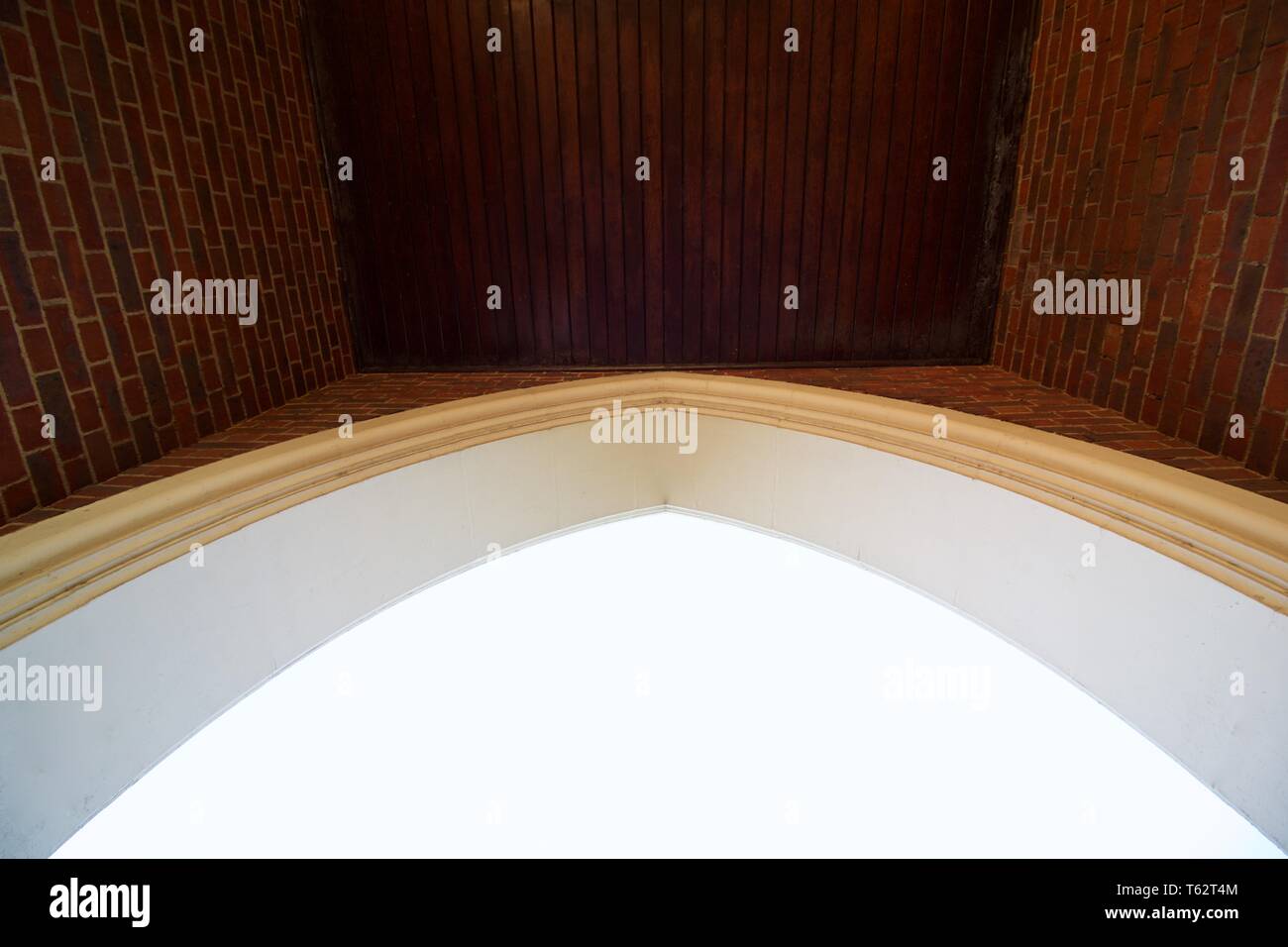 Architectural arch background with bricks to side and wood panelling ...