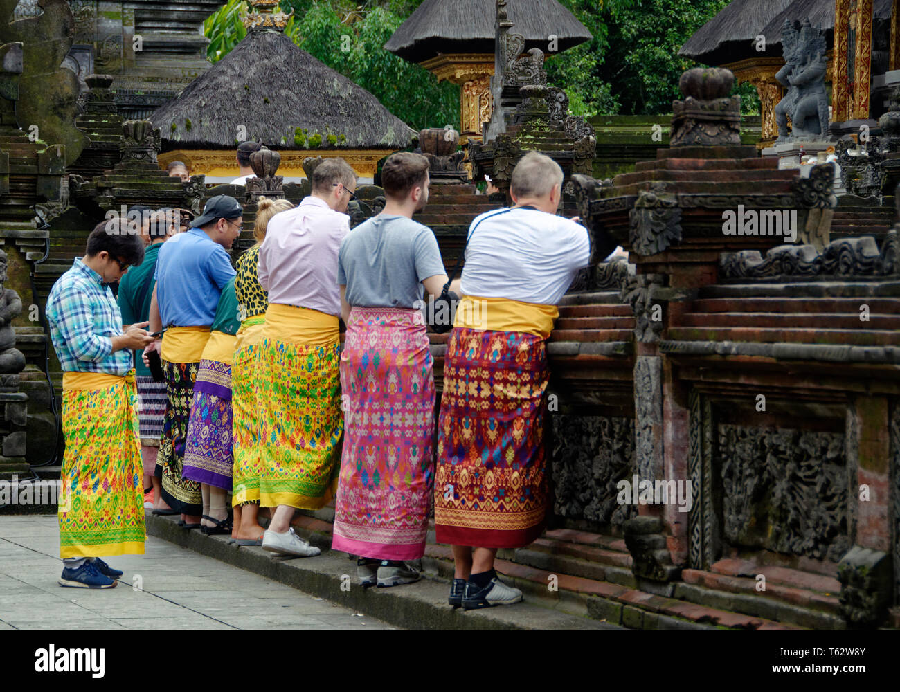 Group of tourists in the compulsory sarongs at Pura Tirta Empul, the ...