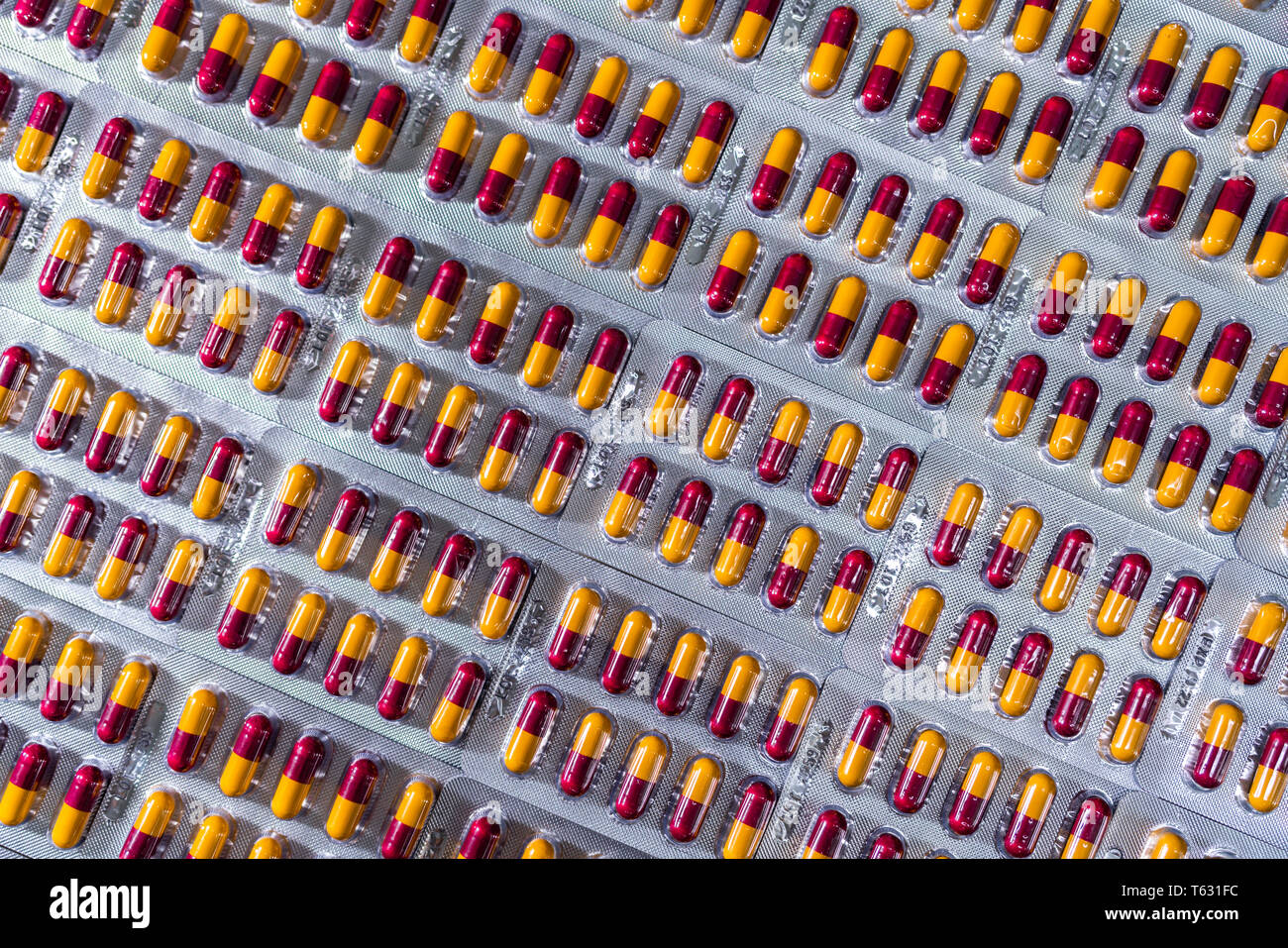 Pharmaceutical industry. Red-yellow capsule pills in blister pack ...