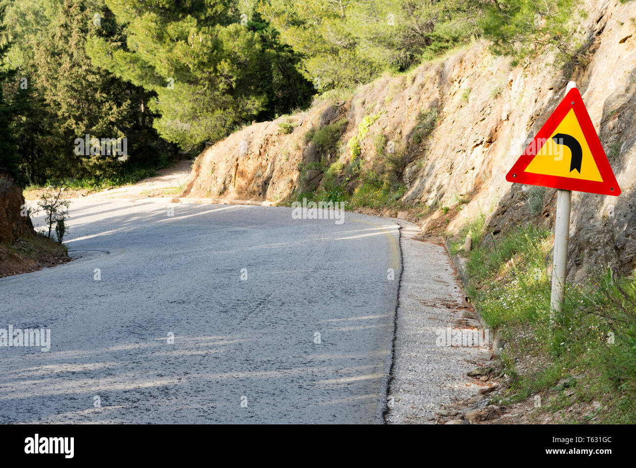 warning sign for dangerous left turn in the mountain Stock Photo - Alamy