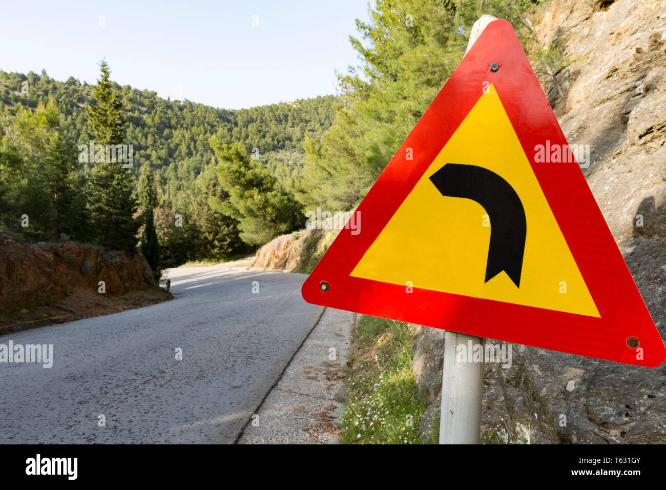 warning sign for dangerous left turn in the mountain Stock Photo - Alamy