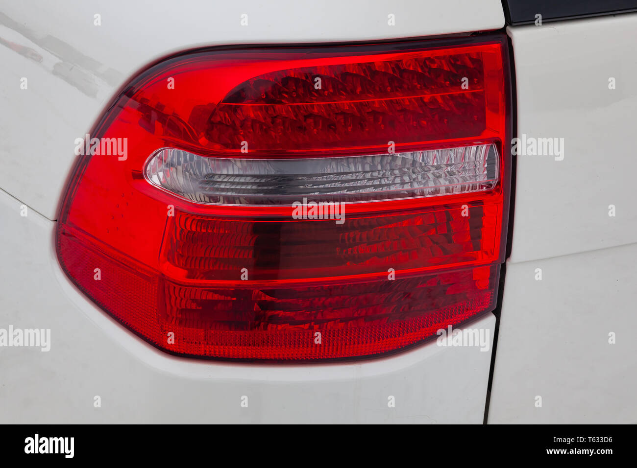 Close-up on the rear LED brake light of red color on a white car in the ...