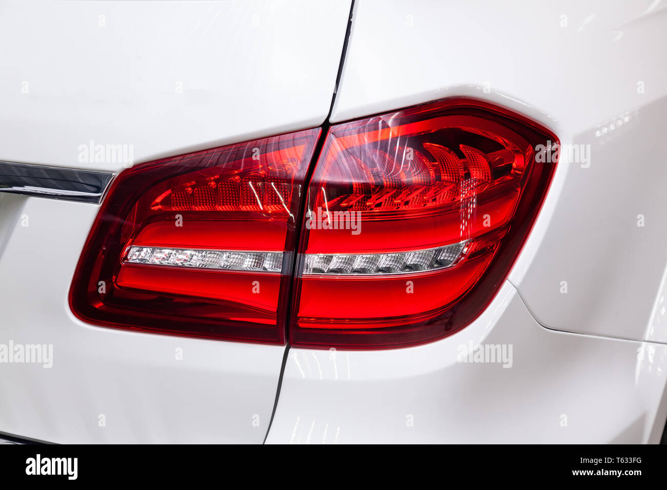 Close-up on the rear LED brake light of red color on a white car in the ...