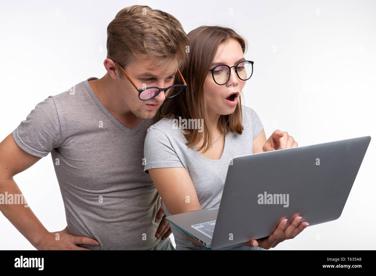 Nerds, study, people concept - a couple of students look at the netbook ...