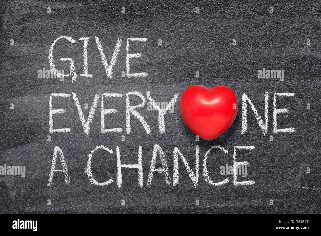 give everyone a chance phrase written on chalkboard with red heart ...