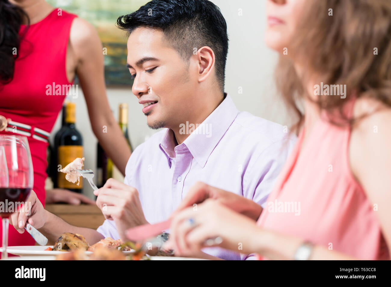 Man eating food with friends Stock Photo - Alamy
