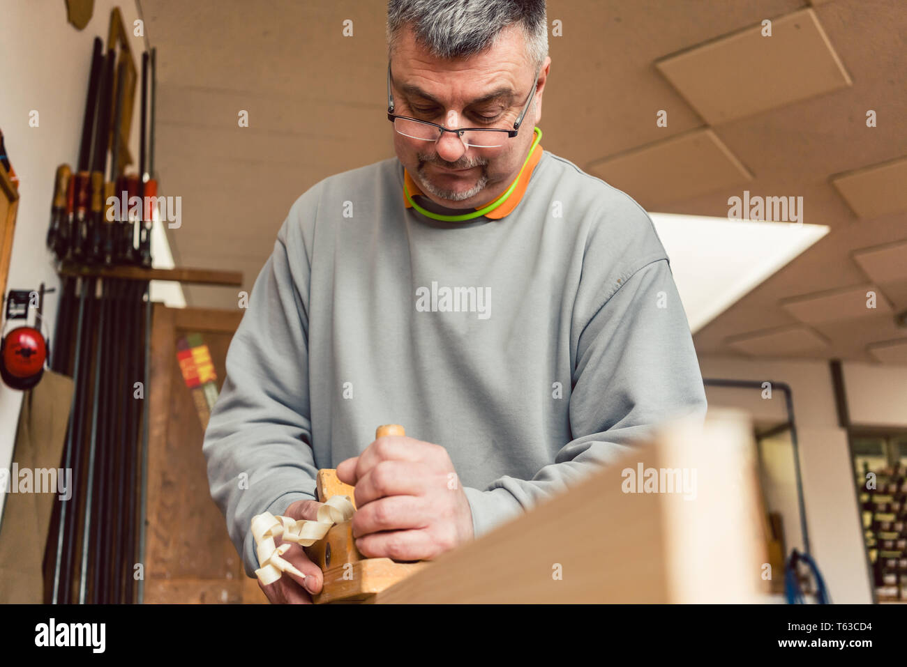 Experienced carpenter planing a board Stock Photo - Alamy
