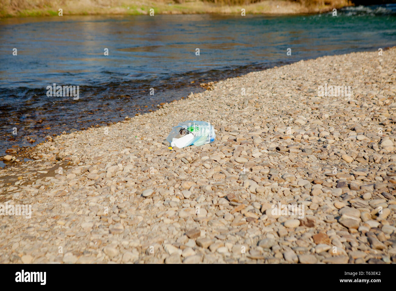 River pollution near the shore, garbage near the river, plastic food ...