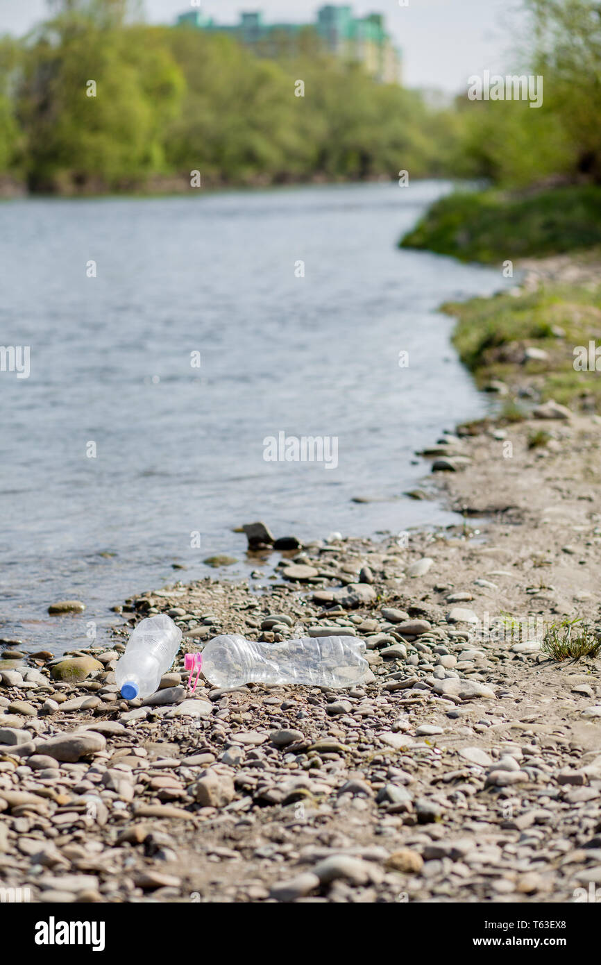 River pollution near the shore, garbage near the river, plastic food ...