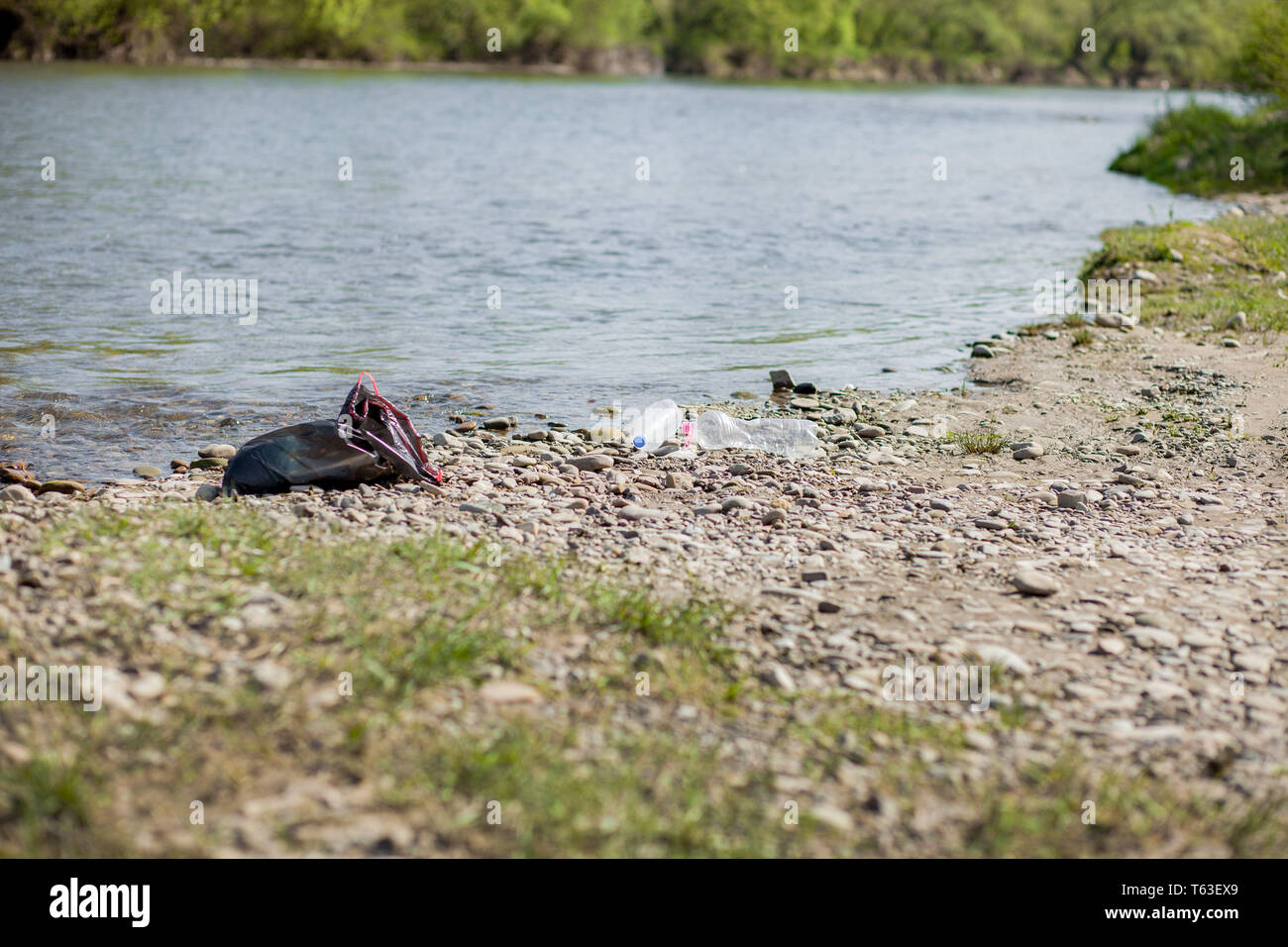 River pollution near the shore, garbage near the river, plastic food ...