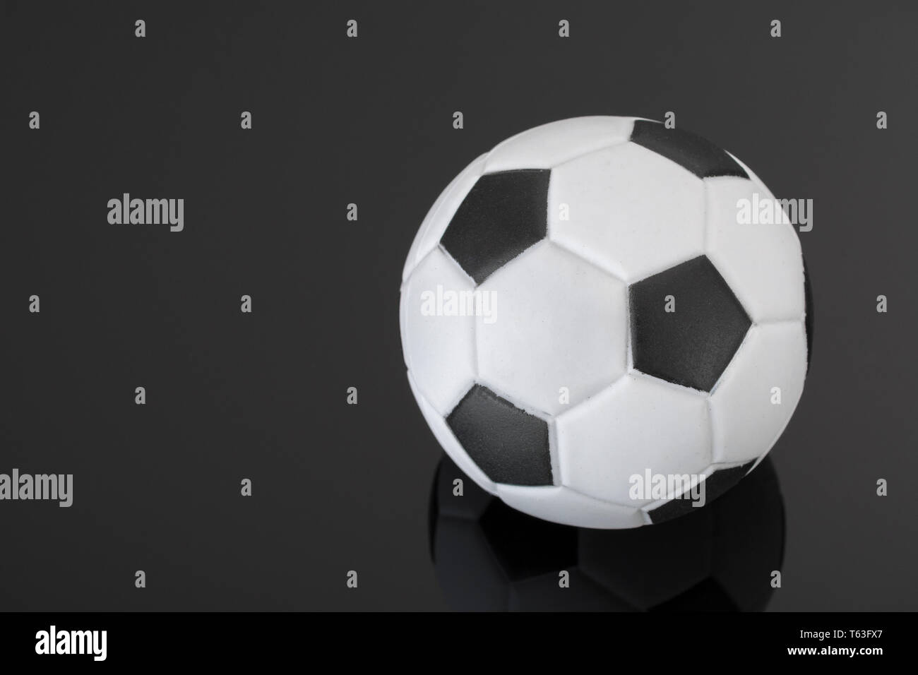Kid's small plastic soccer ball (made in China) against dark background ...