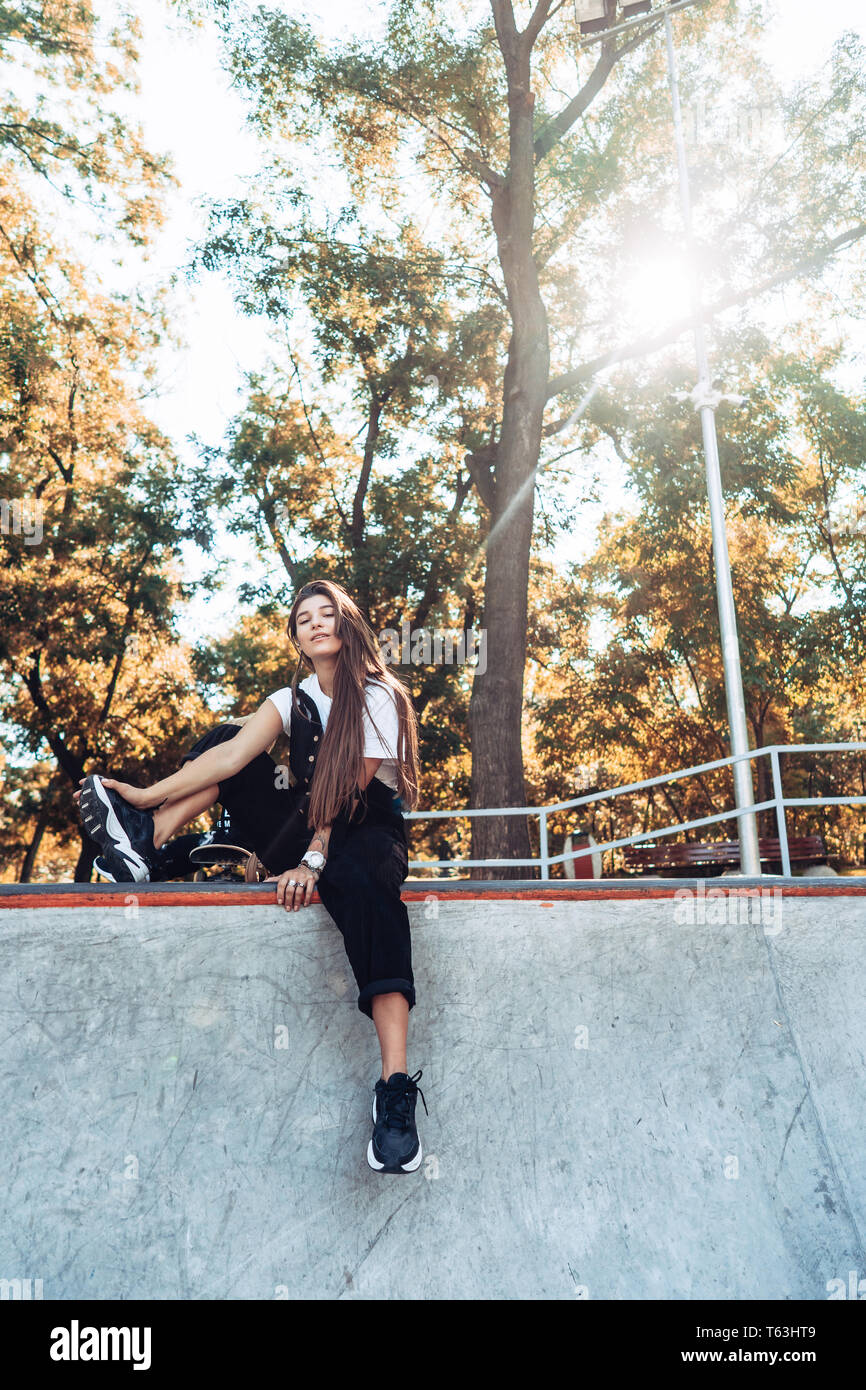 Beautiful young hipster girl sitting on the edge of a ramp Stock Photo ...