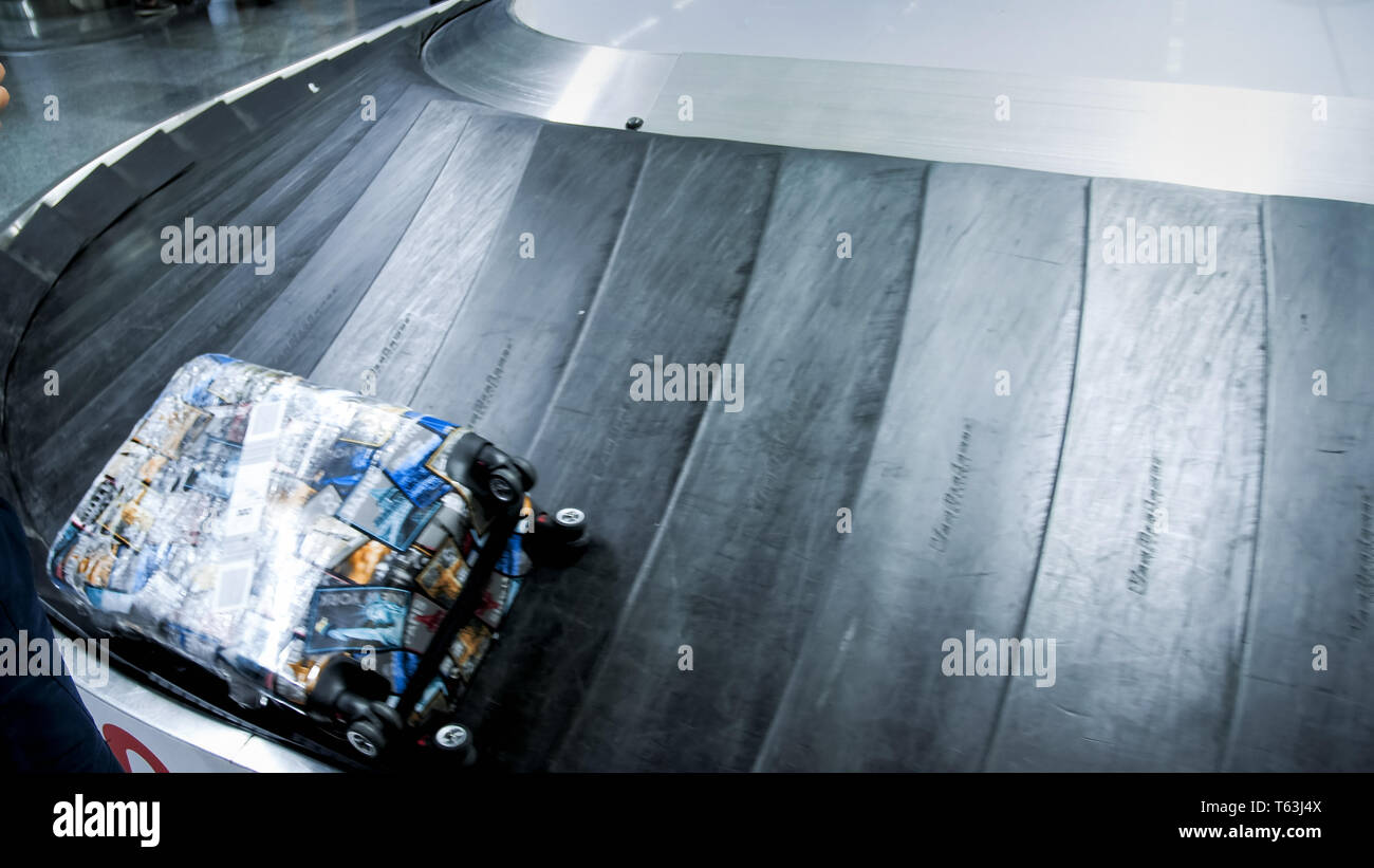 Closeup photo of suitcase lying on luggage claim line at modern airport ...
