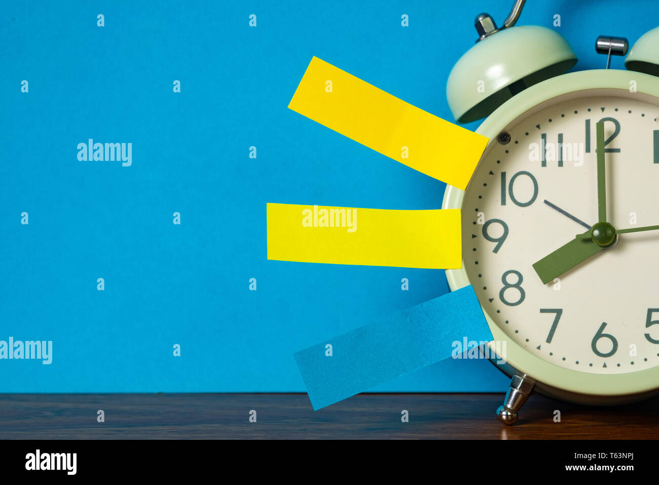 Note paper sticky and vintage alarm clock on table with copy space for ...