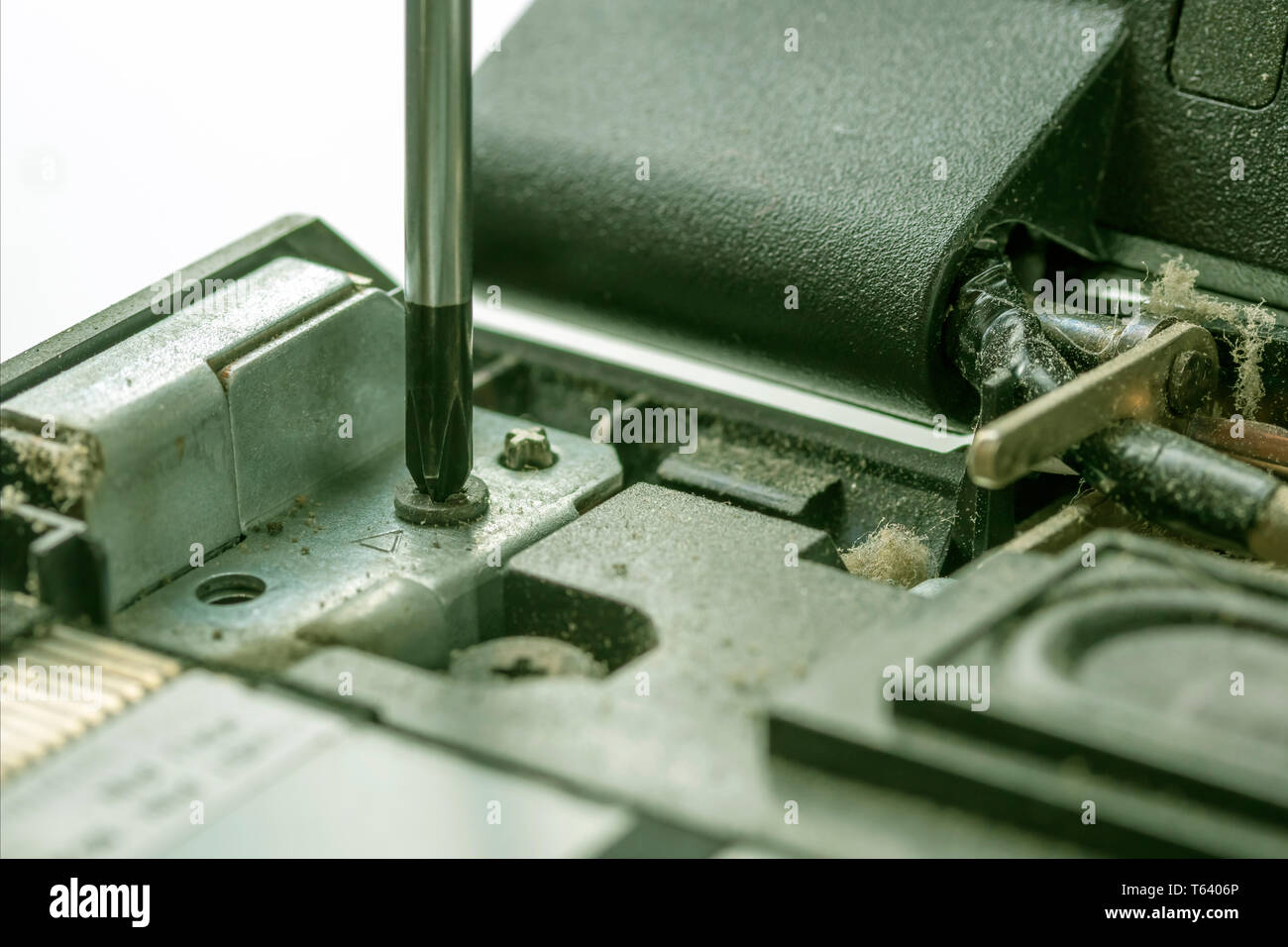 The screwdriver unscrews the fastening bolt of the old dusty processor ...